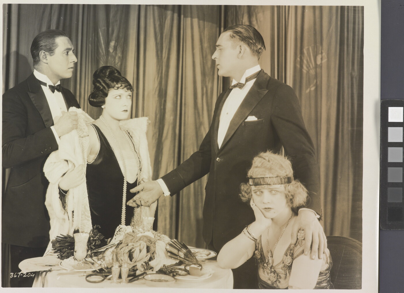 [Elliot Dexter helping Gloria Swanson with coat, Wallace Reid with hand ...